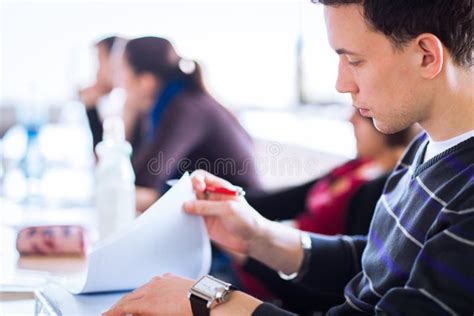 Estudiante Universitario De Sexo Masculino Joven Hermoso Que Se Sienta En Una Sala De Clase Por