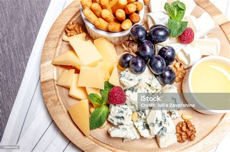 치즈의 다른 종류와 보드 치즈 믹스 세트 도르 블루 체다르 파마산 브리 꿀 소스 손가락 빵과 포도 를 우렌 팔테에 섞는다 레스토랑 메뉴 아침 식사 접시 건강한 간식 구색