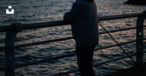 하얀 까마귀와 검은 바지를 입은 남자가 일몰 동안 나무 부두에 서 있다 사진 Unsplash의 무료 멜버른 빅 이미지