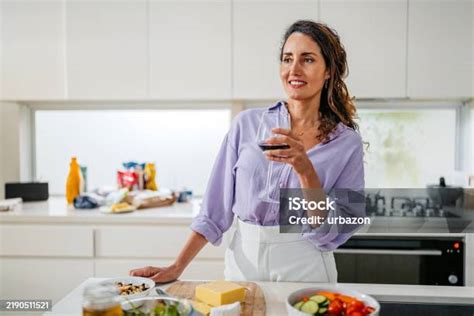 호주 시드니의 부엌에서 식사를 준비하는 동안 와인 한 잔을 마시는 중년 여성 가정 생활에 대한 스톡 사진 및 기타 이미지 가정 생활 가정 주방 가정의 방 Istock