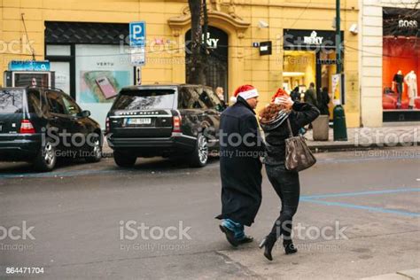 프라하의 크리스마스입니다 알 수 없는 커플남자와 크리스마스 훈장을 가진 프라하의 거리를 걷고 빨간 새 해 모자에 있는 여자 12월에 대한 스톡 사진 및 기타 이미지 Istock