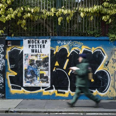 Premium Photo A Man Walks Past A Wall With A Poster For Scribble Wall