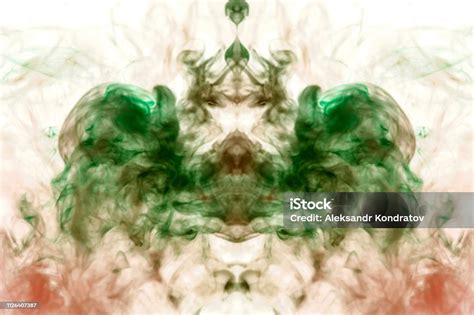 물 안개 자욱한 물질이 뚜렷한 눈을 가진 신비한 귀신의 머리의 형태로 불 같은 오렌지와 녹색 색상의 흰색 배경 T셔츠 인쇄입니다 T 셔츠에 대한 스톡 사진 및 기타 이미지