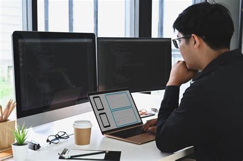 Premium Photo Smart Young Asian Male Programmer Coding At His Desk Using Laptop And Computer