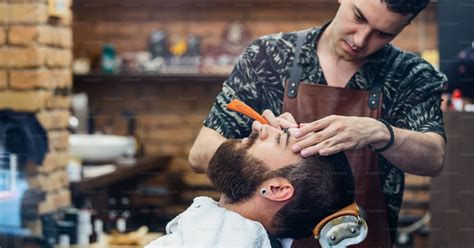 수염 스타일링 및 컷 수염 스타일링의 잘린 사진을 닫습니다 너무 세련 되 고 세련 된 광고 및 이발소 개념 전문 이발사의 손에 면도기 사진 Unsplash의