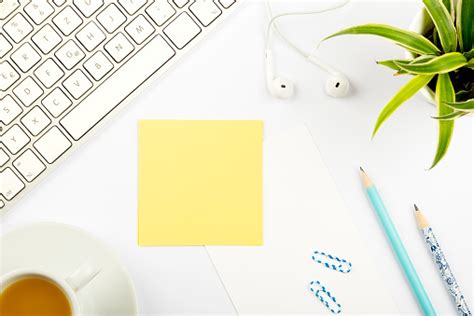 꽃 헤드폰 펜 종이 클립 뜨거운 음료 및 키보드가있는 책상에있는 종이 조각에 대한 중요한 발표 연필과 차가있는 테이블에 대한 중요한 아이디어 0명에 대한 스톡 사진 및 기타