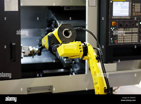 Robot Arm Is Loading Detail Into Cnc Lathe Machine Selective Focus