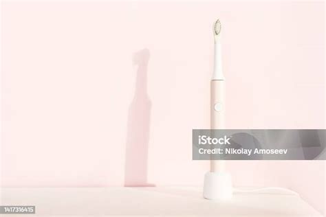 새로운 현대 초음파 칫솔 턱 모델과 분홍색 파스텔 배경에 치과 치료 용품 구강 위생 치과 및 잇몸 건강 건강한 치아 치과 제품 초음파 진동 칫솔 0명에 대한 스톡 사진 및