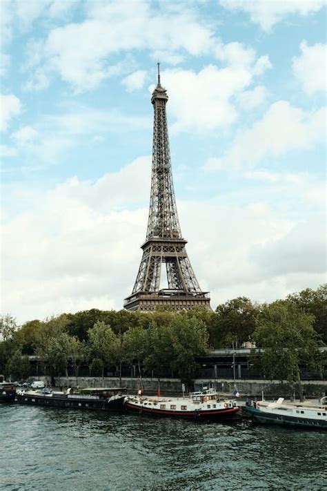 공원 기념물 랜드마크 앉아 있는 에펠탑 여름 여행 잔디 지역 랜드마크 파리 푸른 하늘 프랑스에 관한 무료 스톡 사진