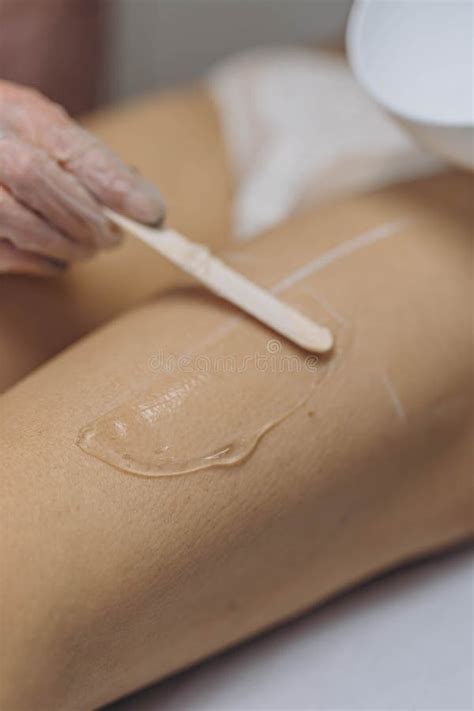 Beautician Applying Gel For Laser Hair Removal On Smooth Female Legs Close Up In A Beauty Salon