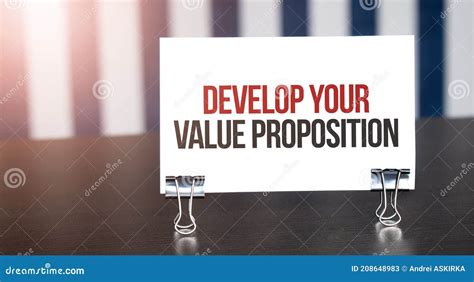 Develop Your Value Proposition Sign On Paper On Dark Desk In Sunlight
