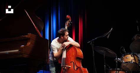 피아노 옆에 서서 첼로를 들고 있는 남자 사진 Unsplash의 무료 음악 이미지