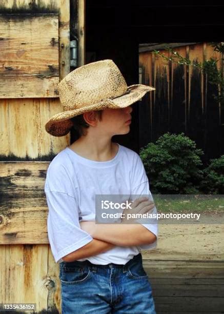 파란 청바지와 카우보이 모자를 입은 초상화 사춘기 소년이 사려 깊은 반사로 헛간 문에 기대어 스톡 사진 10 11세에 대한 스톡 사진 및 기타 이미지 Istock