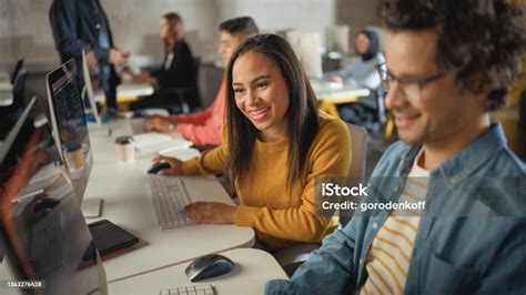 대학 방에 앉아 있는 다양한 다민족 여성 및 남성 학생 그룹 컴퓨터로 학교 프로젝트에 협력 젊은 학자들은 수업에서 학업 능력과 지식을 연구하고 이야기하고 적용합니다 컴퓨터에