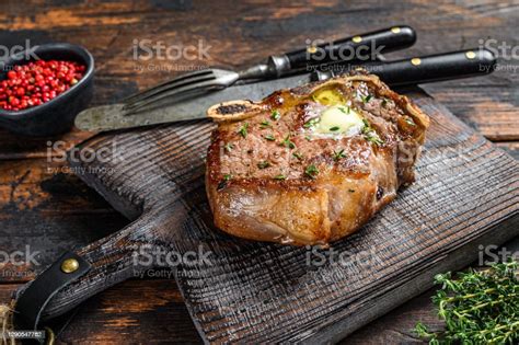 뼈에 구운 클럽 쇠고기 스테이크 또는 스트리플로인 어두운 나무 배경 위쪽 보기 고기에 대한 스톡 사진 및 기타 이미지 고기 구이 굽기 Istock