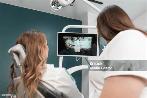 현대 의료 센터에서 치과는 정확한 진단을 위해 구강 Mri 결과를 확인합니다 치과 의사는 Ct 영상을 분석한 후 환자에게 치료 전망을 설명합니다 2명에 대한 스톡 사진 및