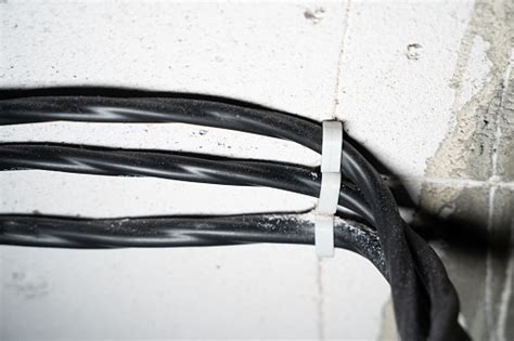 3 개의 검은 색 전원 와이어가 폭기 된 콘크리트 벽돌에 평행하게 부착됩니다 가스 블록 클로즈업 벽의 전기 배선 0명에 대한 스톡 사진 및 기타 이미지 Istock