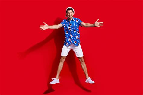 잘 생긴 젊은 남자가 손을 뻗고 포즈를 취하는 전신 사진 옷을 입은 산타 클로스 프린트 Xmas 의상 빨간 색 배경에 고립 25 29세에 대한 스톡 사진 및 기타 이미지