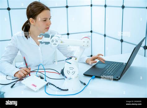 Student Girl Sets Up A Robot Model At The University Laboratory Of Electronics And Automation