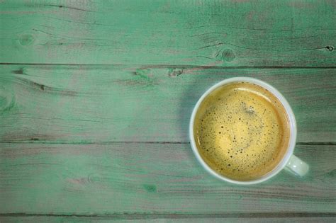 카푸치노 또는 라떼 커피를 우드 테이블 배경에 흰색 세라믹 컵 커피에 우유 거품으로 클로즈업 복사 공간이 있는 맨 위 뷰를