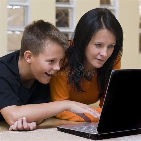 Madre E Hijo Que Mienten En El Suelo Con La Computadora Portátil Imagen