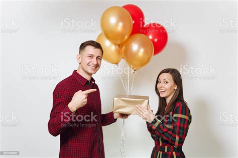 아름 다운 젊은 행복 미소 커플 사랑에 여자와 남자와 황금 선물 상자를 들고 제시 하 고 빨강 노랑 흰색 바탕에 생일 축 하