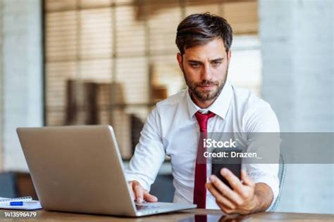 현대 사무실에서 노트북으로 작업하고 스마트 폰을보고 풀 슈트를 입은 사업가 넥타이에 대한 스톡 사진 및 기타 이미지 넥타이 사무실 Brand Name Online