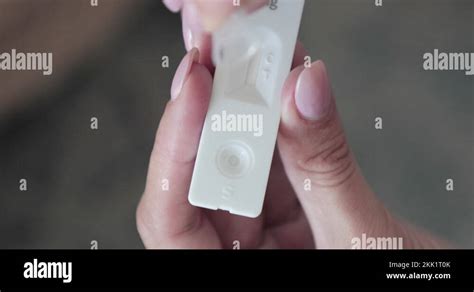 Dropping Lysis Buffer From Test Tube Into Sample Window Of Antigen Test