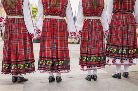 Back View Of Women In Traditional Red Folk Dresses During Folk Dance