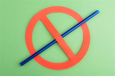 플라스틱 없음 금지에 작은 파란색 빨 대 녹색 배경 위에 표시 환경에 미치는 영향으로 인해 플라스틱 빨 대의 흔적을 보여주는 평면도 텍스트의 공간을 복사 합니다 0명에 대한