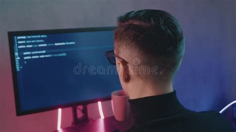 Programmer Coding On A Computer In The Dark With A View Of The Lights Of The Night City The