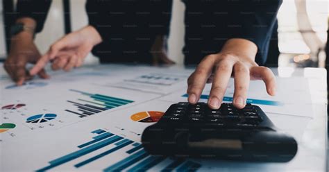 재무 문서 세금 회계 통계 및 분석 연구 개념을 계산하기 위해 계산기를 사용하여 사업가와 파트너를 닫습니다 사진 Unsplash의 계산기 이미지