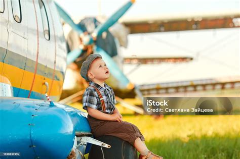 한 어린이가 오래된 비행기 근처에 서서 자라면서 조종사가 되는 꿈을 꾸고 있습니다 미래의 직업을 선택하는 개념 2 3 살에 대한 스톡 사진 및 기타 이미지 Istock
