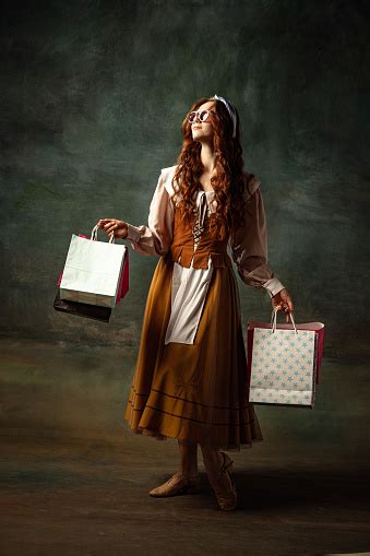 시대 비교 어두운 배경에 고립 된 르네상스 시대의 소녀처럼 긴 곱슬 머리를 가진 젊은 Atractive 빨간 머리 소녀 쇼핑 뷰티 예술 블랙 프라이데이 11월에 대한 스톡