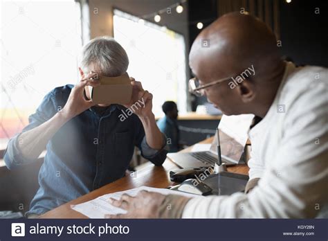 Senior Male Designers Testing And Programming Virtual Reality Simulator Glasses In Office Stock
