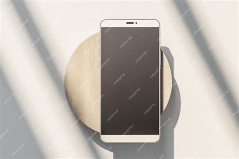 Пустой черный экран мобильного телефона на деревянном цилиндре на абстрактном солнечном белом