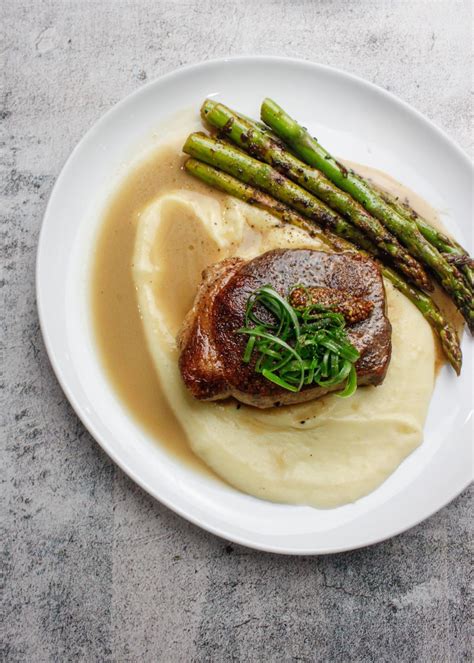 Dry Aged Pork Chop On Potato Purée Served With Pork Stock Reduction And