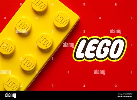 Close Up Of Large Yellow Lego Block With The Lego Logo Over Red