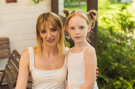 여름에 주근깨가있는 어머니와 빨간 머리 소녀의 초상화가 흐려진 배경 쾌활하고 행복한 어린 시절 여름 방학 야외 레크리에이션 돌보는 부모 행복한 미소 2명에 대한 스톡 사진