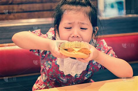 汉堡包可爱的小女孩在吃。