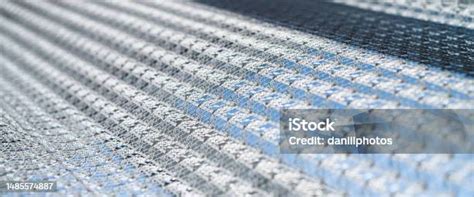 파랗고 햇살이 내리쬐는 하늘의 흐릿한 배경에 있는 창문에 있는 아름다운 하얀 얇은 명주 그물 흰색 투명 커튼 패턴 근접 촬영 보케가 있는 대각선의 섬세한 커튼이 있는 밝고