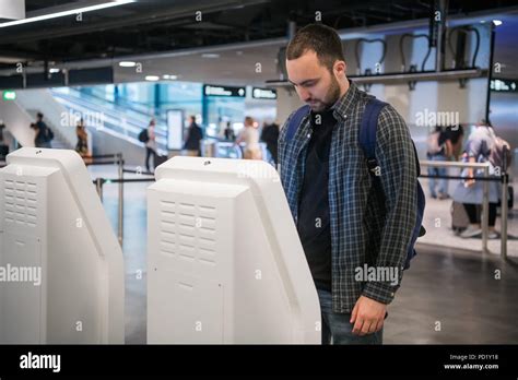 Happy Man Using The Check In Machine At The Airport Getting The