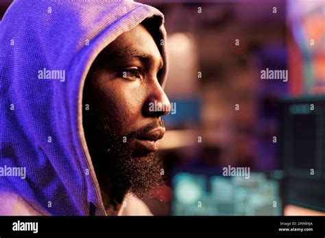 african american hacker in hood breaking into computer network system