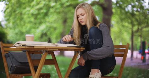 Female Caucasian Student In Park Stresses Over Difficult Class Material