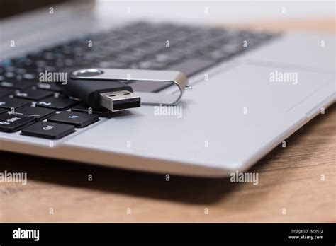 USB Memory Stick Or Flash Drive On The Keyboard Of An Open Laptop Viewed Close Up Low Angle With
