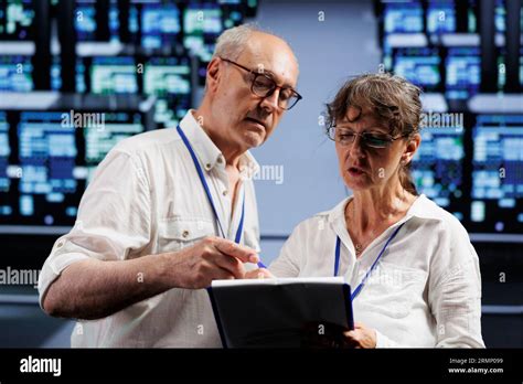 Elderly Computer Scientists Monitoring Data Center Racks Optimizing