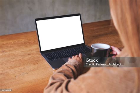 커피를 마시는 동안 빈 흰색 데스크톱 화면이있는 랩톱 컴퓨터에서 사용하고 타이핑하는 여성의 모형 이미지 35 39세에 대한 스톡