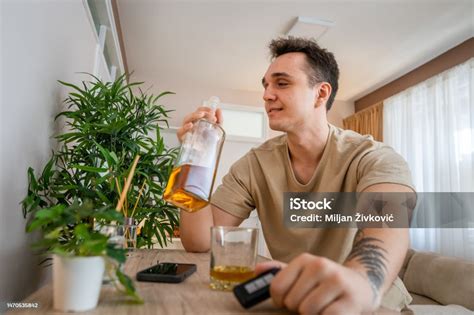 한 남자가 술 한 병을 들고 집에 앉아 위스키를 마시고 술에 취해 알코올 중독 중독 및 남자 우울증 개념 복사 공간 25 29