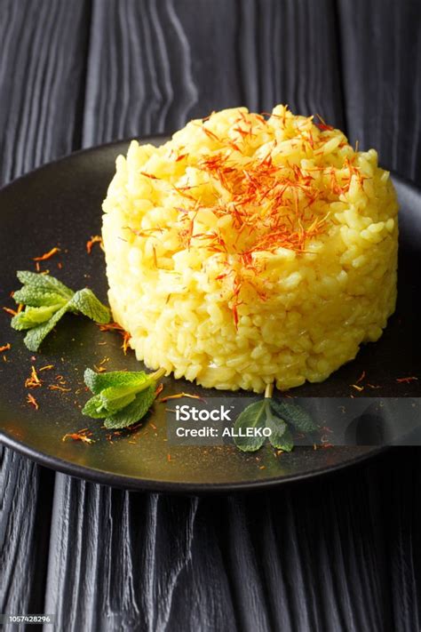 사프란으로 전통적인 리조또 알라 밀라 네 세 접시에 근접 촬영 민트로 장식 되어있습니다 수직 리조또에 대한 스톡 사진 및 기타