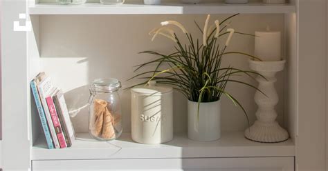 그릇과 병은 흰색 나무 4 층 선반에 담겨 있습니다 사진 Unsplash의 무료 집 이미지